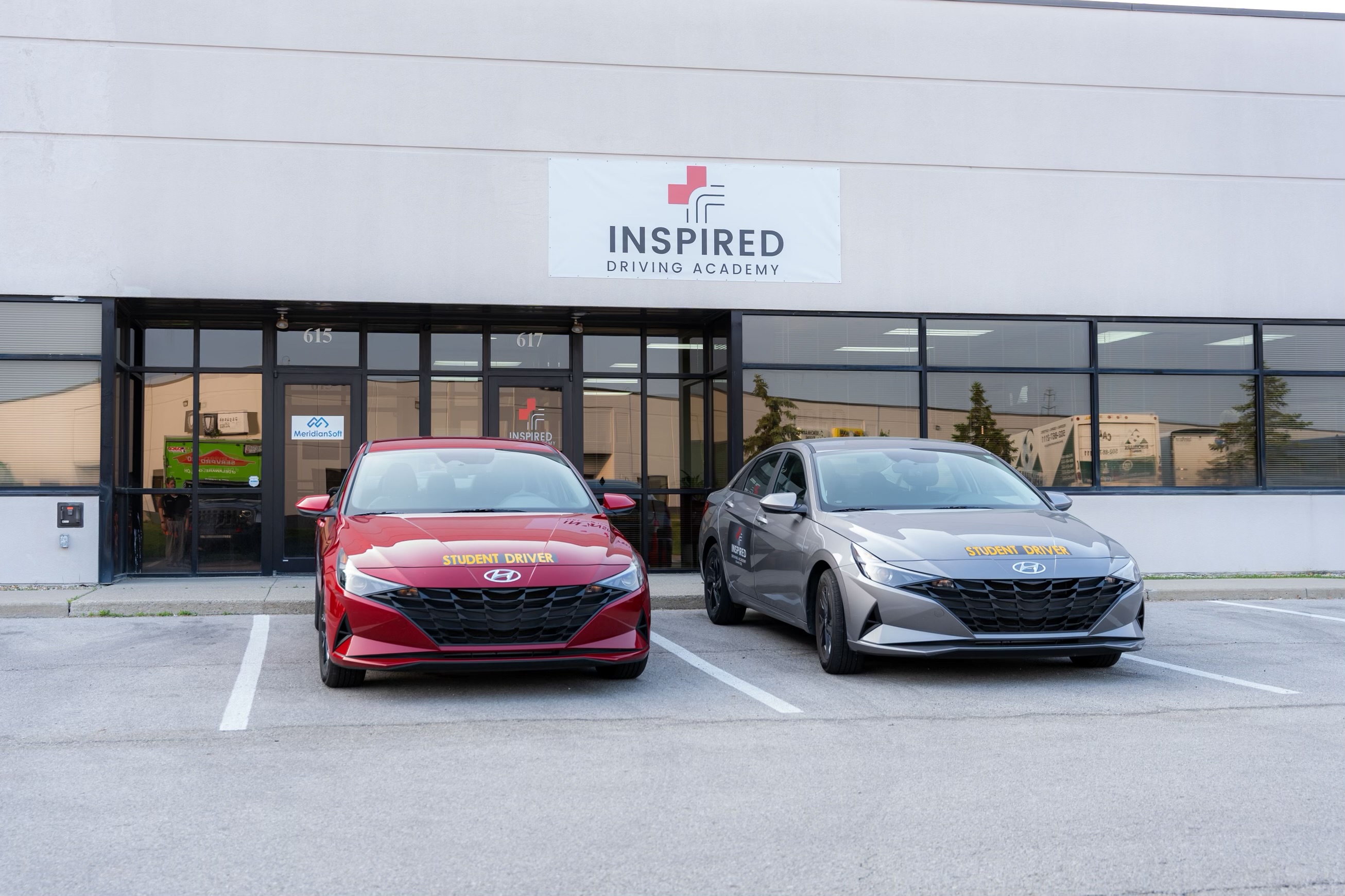 Cars in front of building – Inspired Driving Academy
